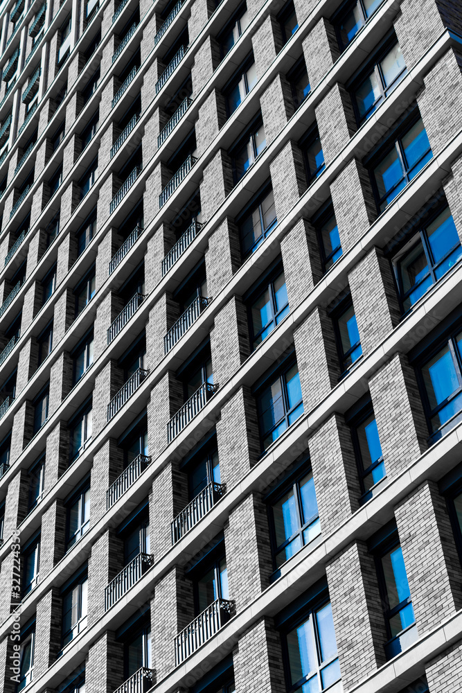 many Windows of a skyscraper. brick walls with Windows. The texture of ...