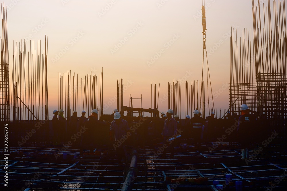 The construction of a rooftop high rise building, workers are tied with ...