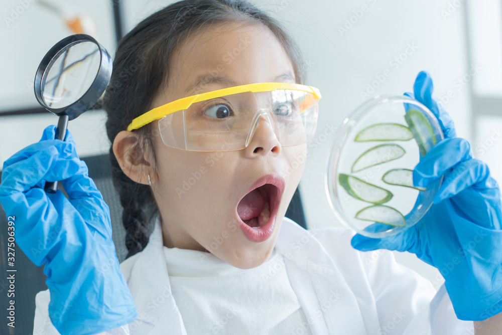 little asian girl elementary school looking into magnifying glass at ...