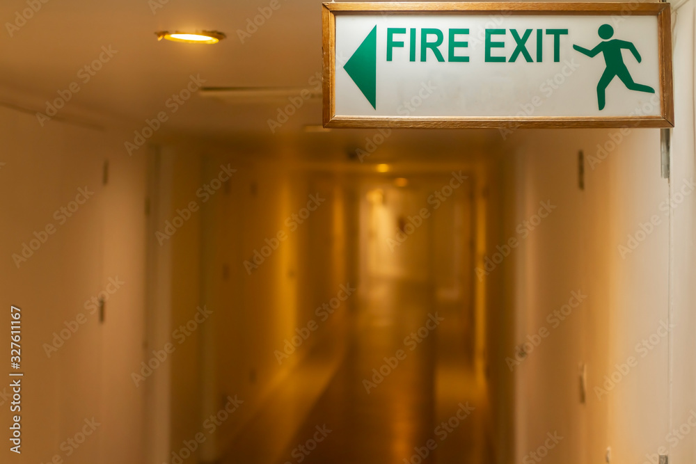 Focus to the fire exit sign of blurred long walking way inside ...