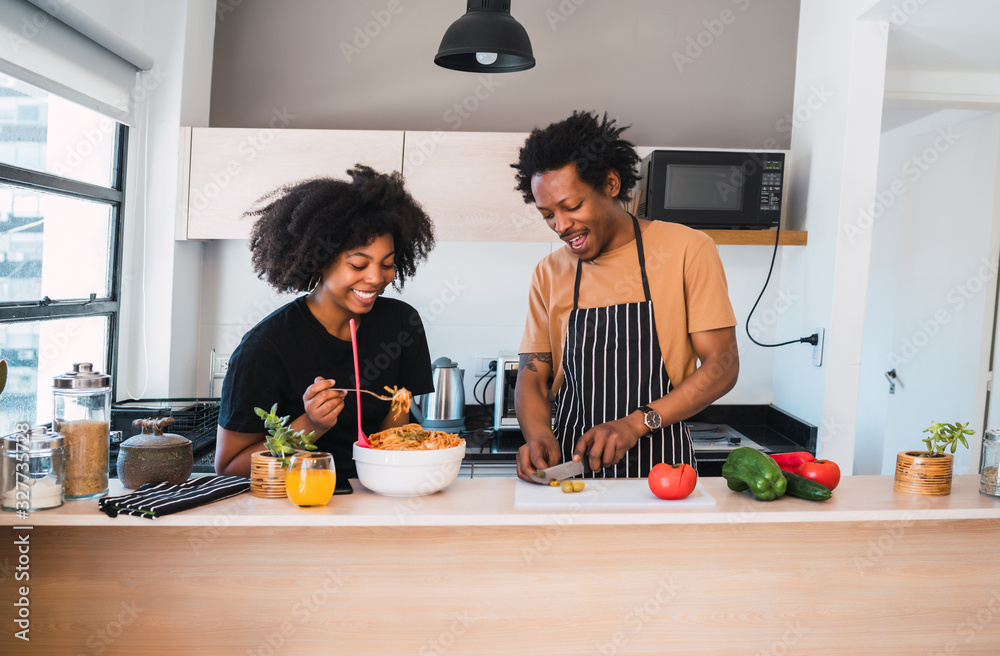 Afro couple cooking together in the kitchen. Stock Photo | Adobe Stock