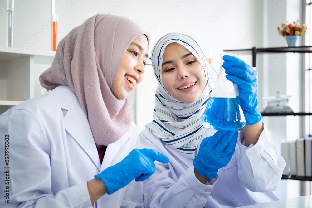 Happy Asian muslim scientist student investigating a chemistry together ...