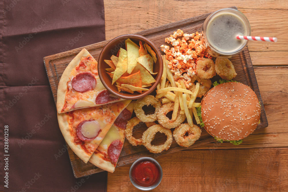 Fast food concept with greasy fried onion rings, burgers, and pizza ...