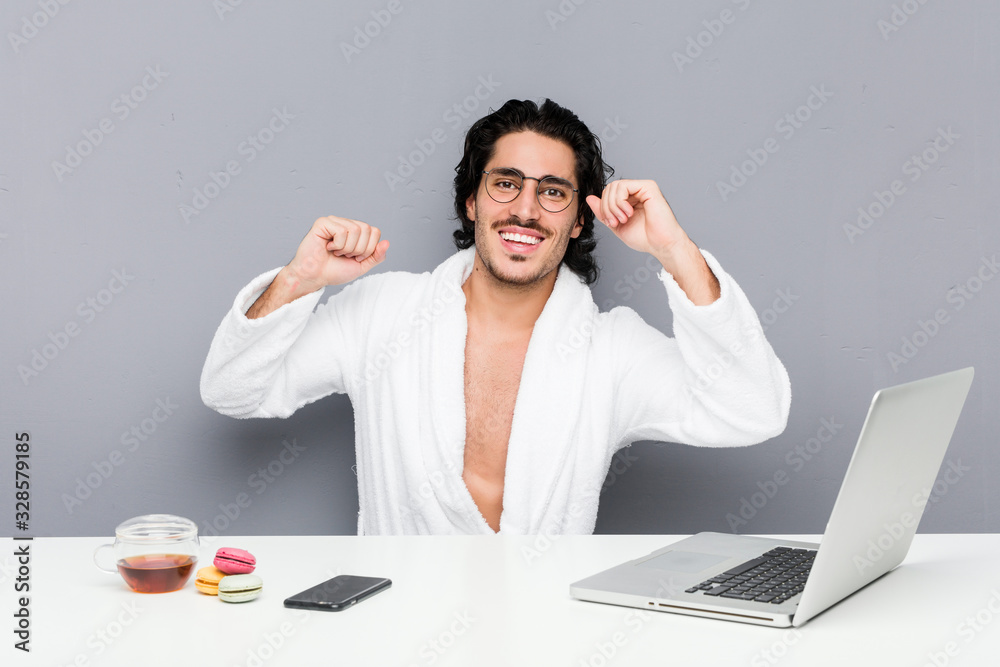 Young handsome man working after a shower celebrating a special day ...
