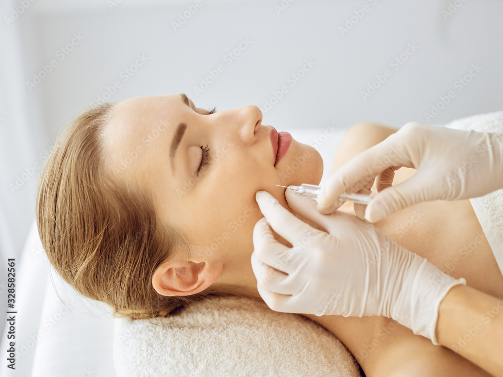 Beautiful woman receiving beauty injections with closed eyes ...