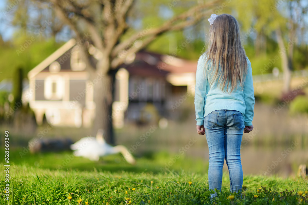 Cute young girl having fun by a pond on warm and sunny summer day. Kid ...