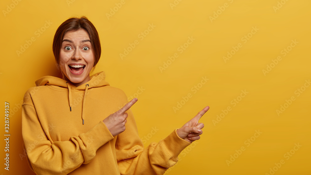 Wow, have look there. Pleased smiling woman shows something appealing ...