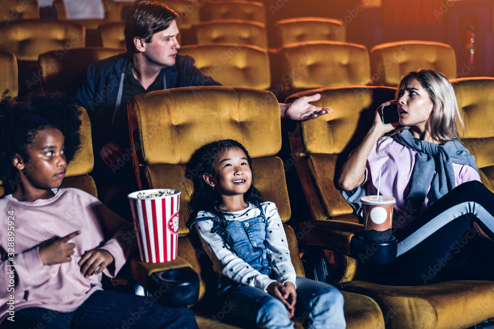 Caucasian woman talking on phone in the cinema and showing a rude ...