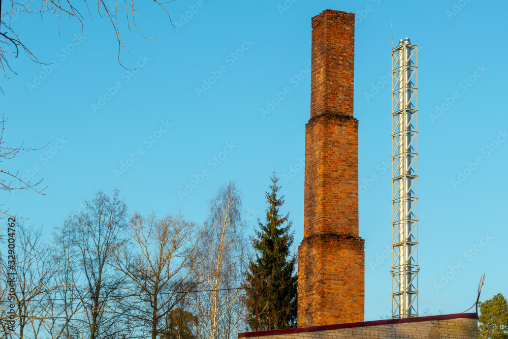 Two chimneys of a boiler room. Brick and iron. The concept of replacing ...