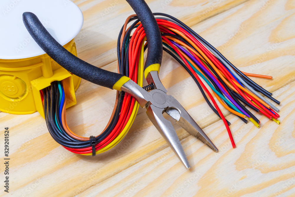 Electrical junction box with wires and tool on wooden boards usually ...