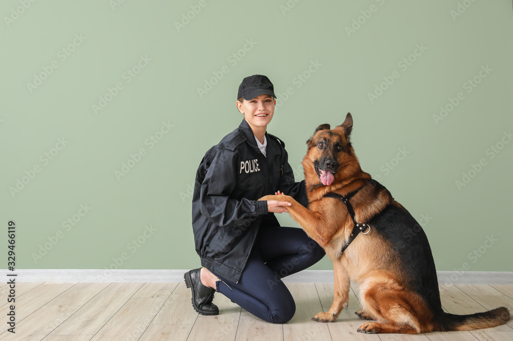 Female police officer with dog near color wall Stock Photo | Adobe Stock