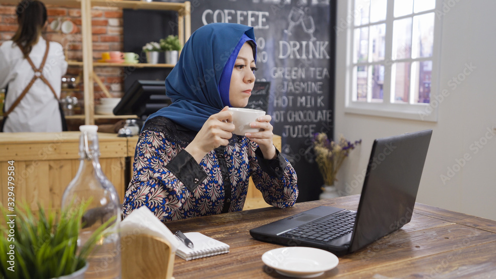 thoughtful muslim businesswoman in blue hijab at cafe store. Arabic ...