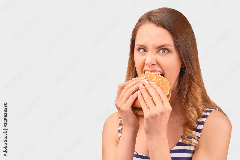 Cute girl quickly eats Burger, wrinkling nose, getting angry, Baring ...