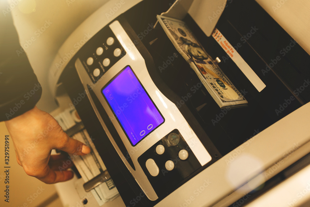 Machine for counting money and 100 dollar bills Stock Photo | Adobe Stock