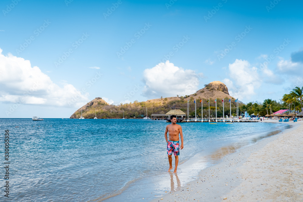 St Lucia Caribbean Island, young men relaxing on the beach during ...