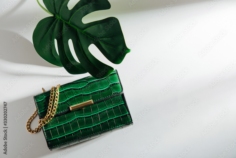 Fashion green handbag with tropical leaf. on white background. Flat lay ...