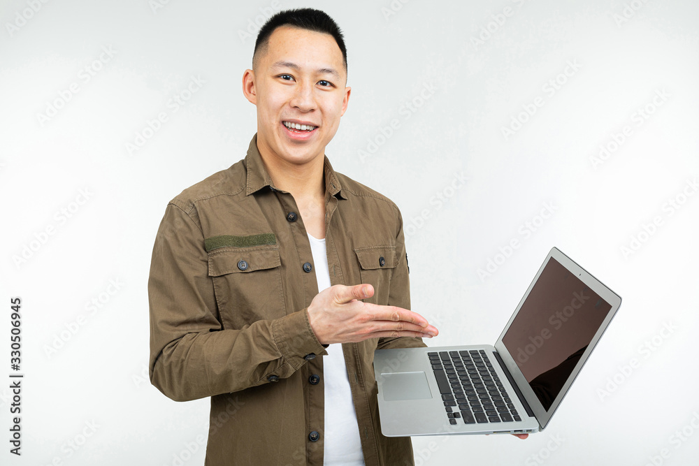 Asian man typing on a laptop keyboard on a white studio background ...
