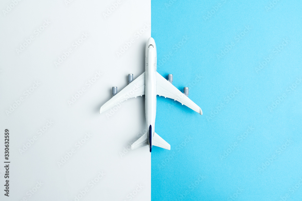 Flat lay miniature airplane model isolated on white and blue background ...
