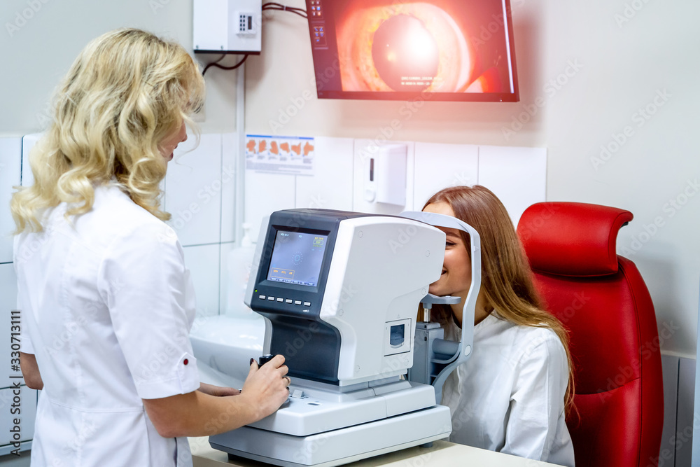 Young woman checking vision. Medical examination at the ...