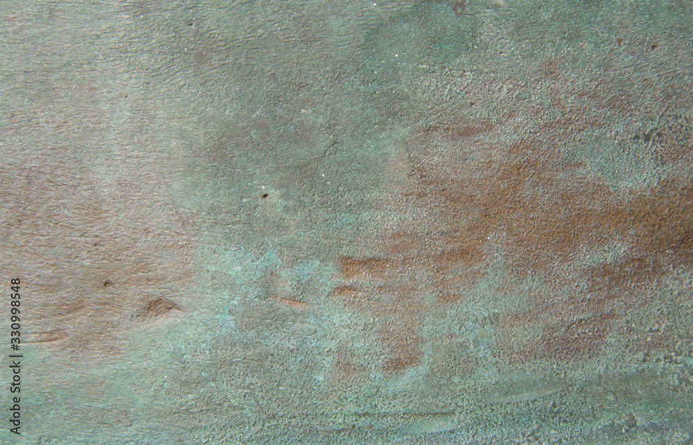 Background of green oxidized bronze with potholes and interspersed ...