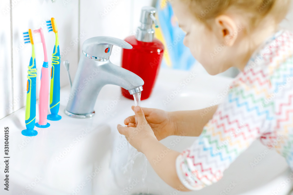 Closeup of little toddler girl washing hands with soap and water in ...