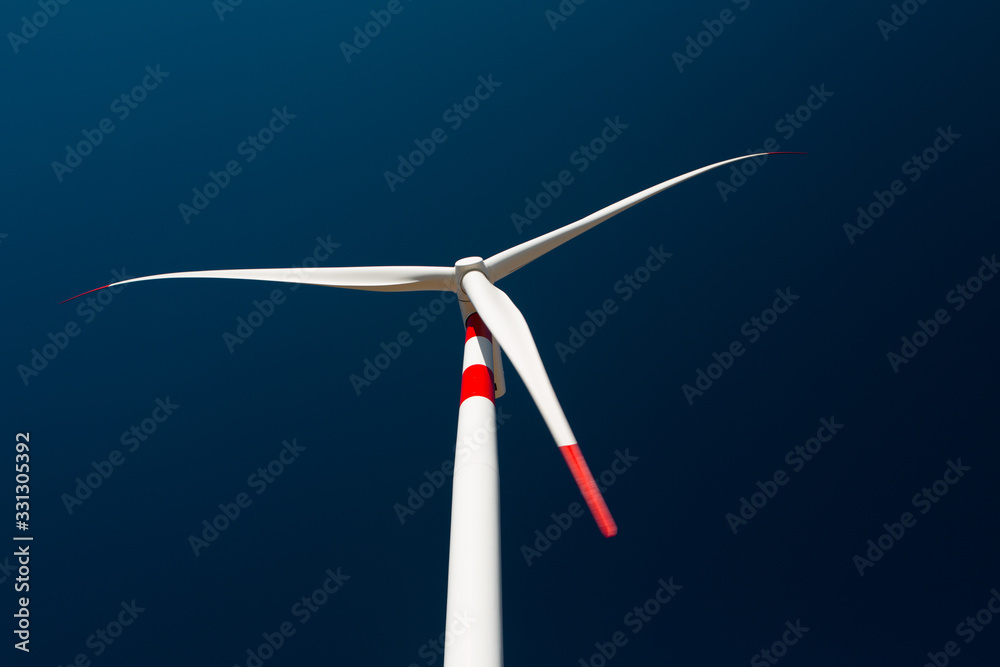 White and red wind turbines on a clear blue sky background in a wind ...