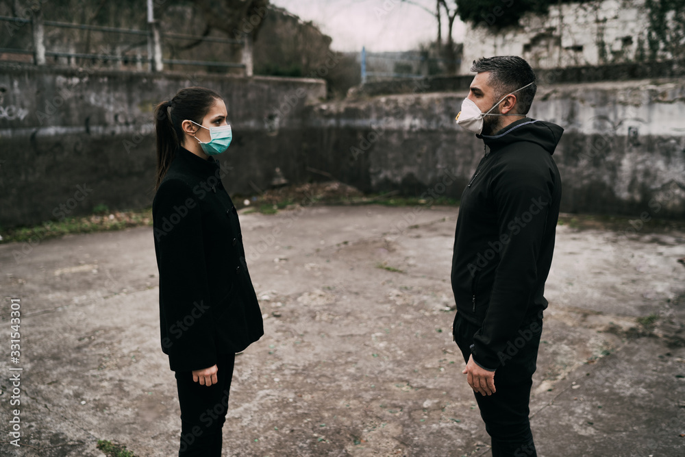 Foto de Stock Two people in masks talking from distance.Couple being ...