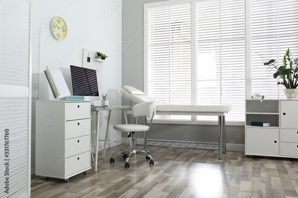 Modern medical office interior with computer and examination table ...