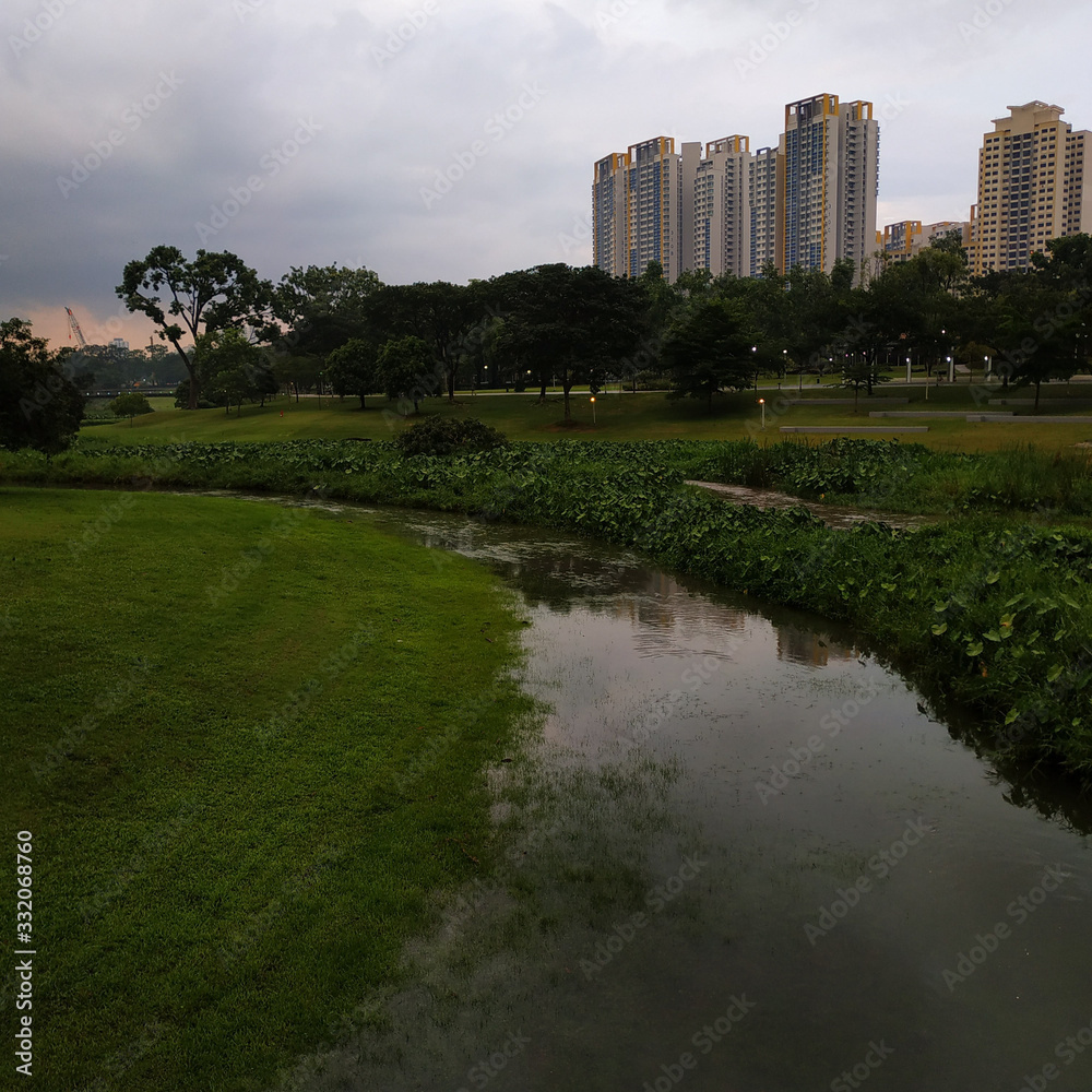reflection of the residential buildings behind a neighborhood park pond ...
