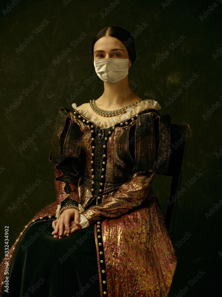Medieval young woman as a duchess wearing protective mask against ...