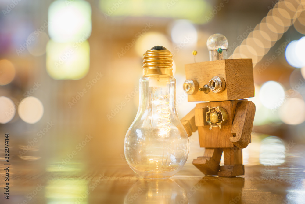 Retro wood robot hold light bulb with two hand with bokeh light ...