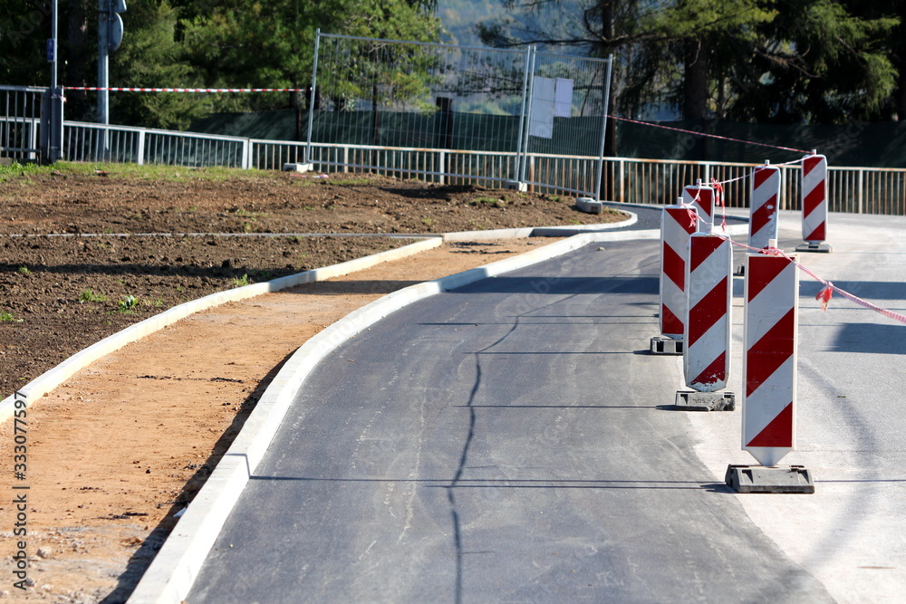 Freshly paved road still under construction filled with stripped red ...