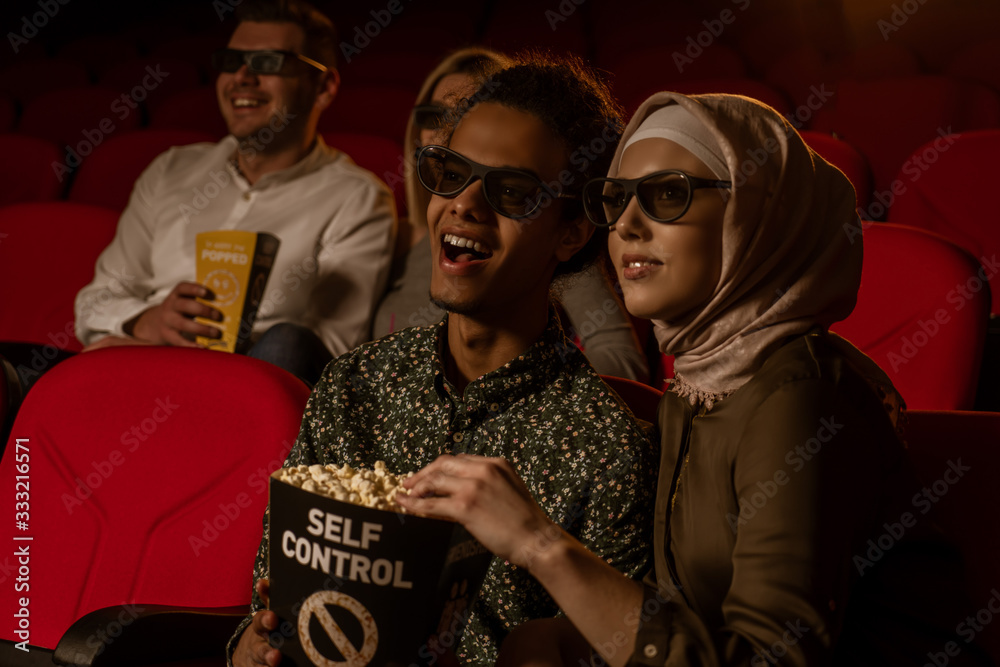 Foto African american muslim man with his wife sitting in movie theater ...