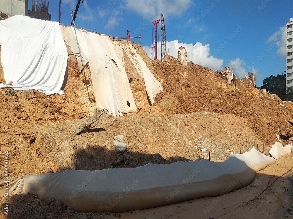 The geotextile fabric is spread over the surface of the slope to ...
