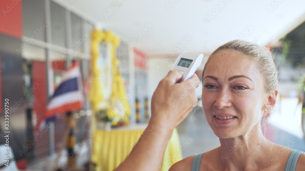 Temperature check at a supermarket of woman, grocery store with thermal ...