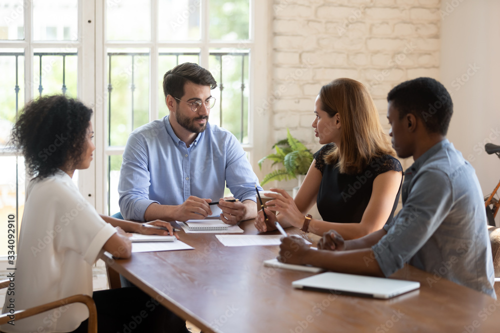Four diverse business partners negotiating in boardroom. Businesspeople ...