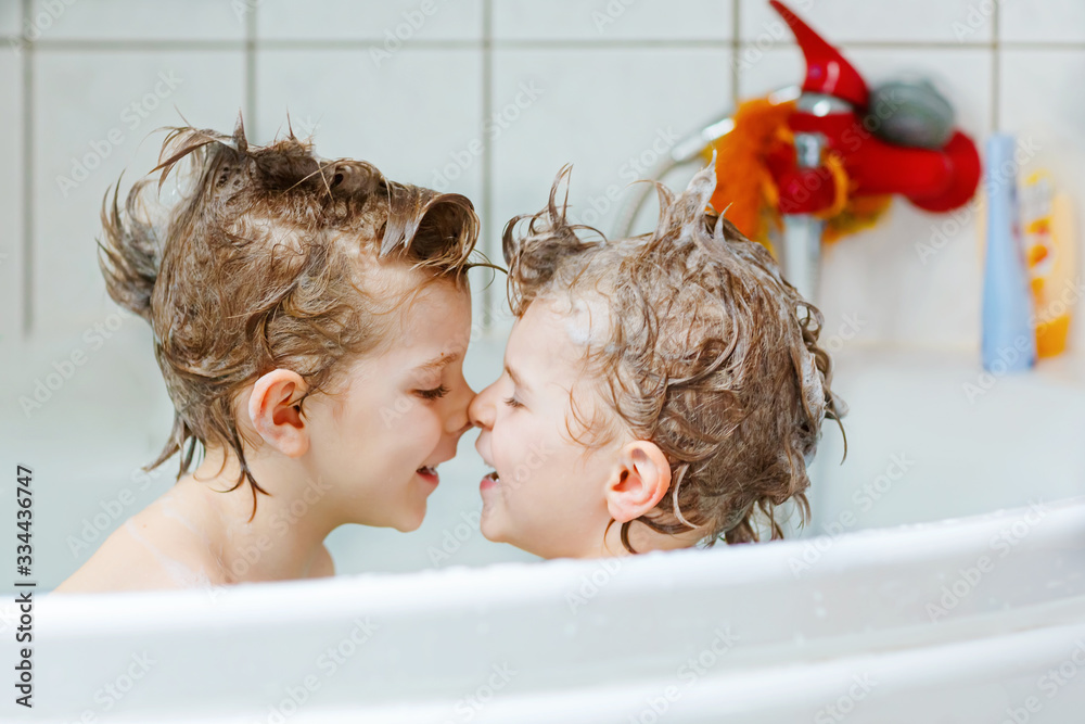 Happy siblings: Two little healthy twins children playing together with ...