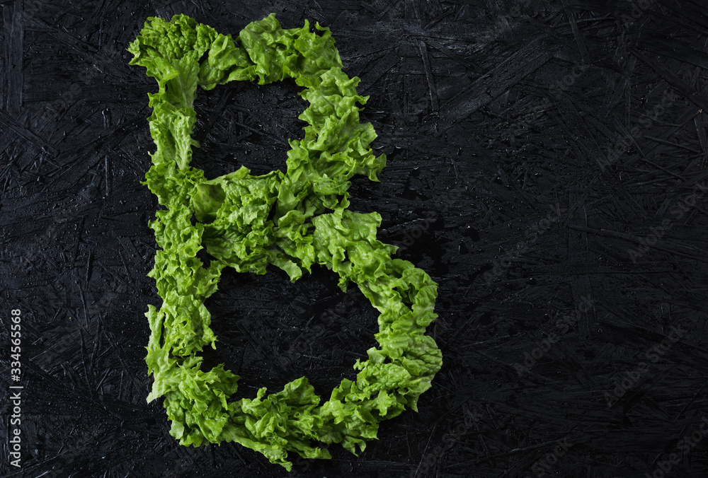 letters of vitamins ABCDE from mint, lettuce, onion, spinach and ...