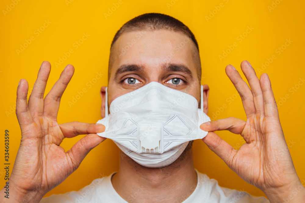 Close up photo of a young bearded white man with a medical face mask ...