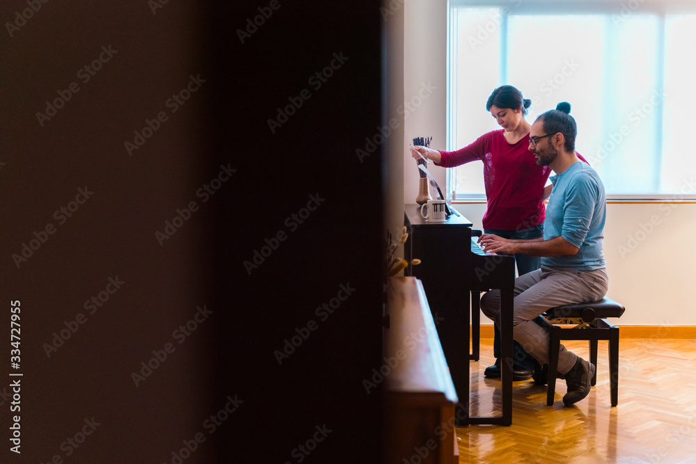horizontal side view of man practicing musical lessons indoors. House ...