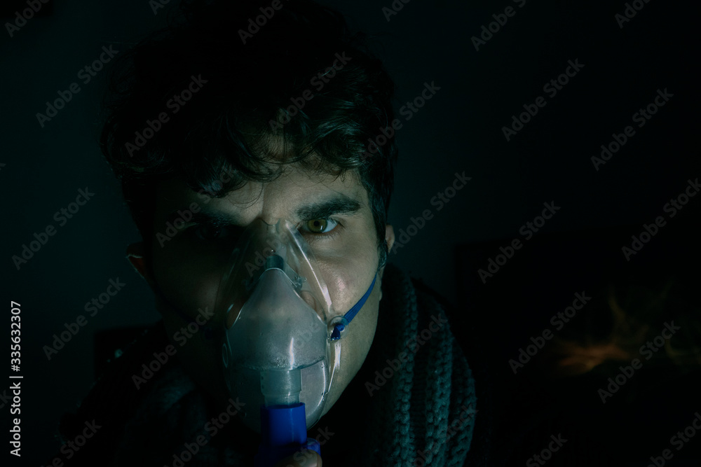 Dark Portrait of man using steam vapor inhaler nebulizer doing aerosol ...
