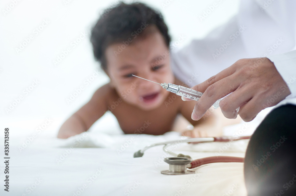 Doctor holds an injection syringe for baby , Dark skinned baby looking ...