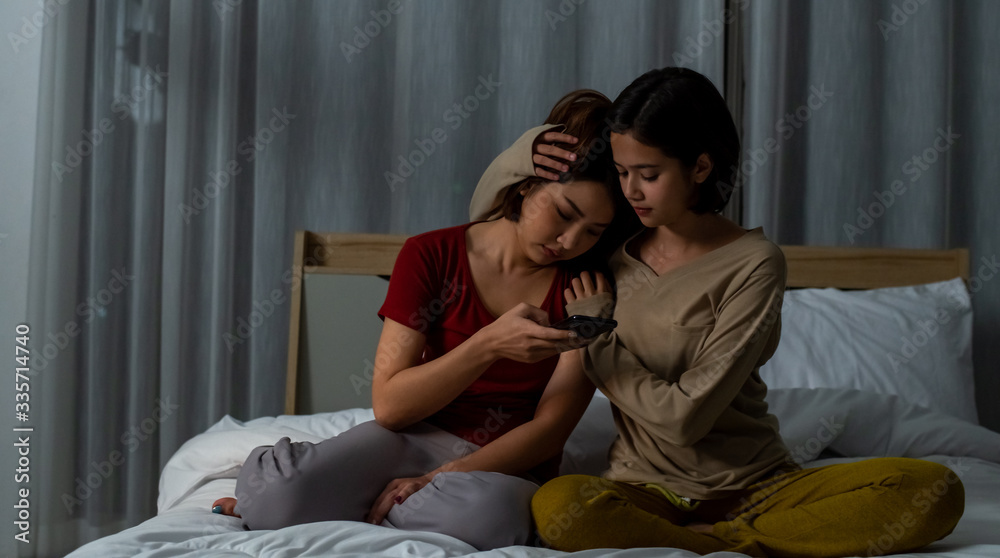 Young beautiful Asian woman comforting her sad girl friend that get bad ...