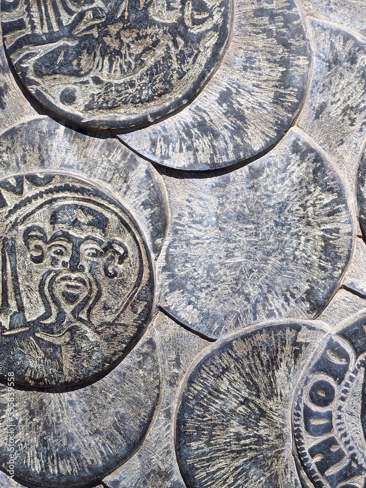Historic coins of Florence in Italy seen on an outside wall of a church ...
