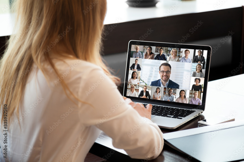 Pc screen view over woman shoulder at group video call. Visual ...