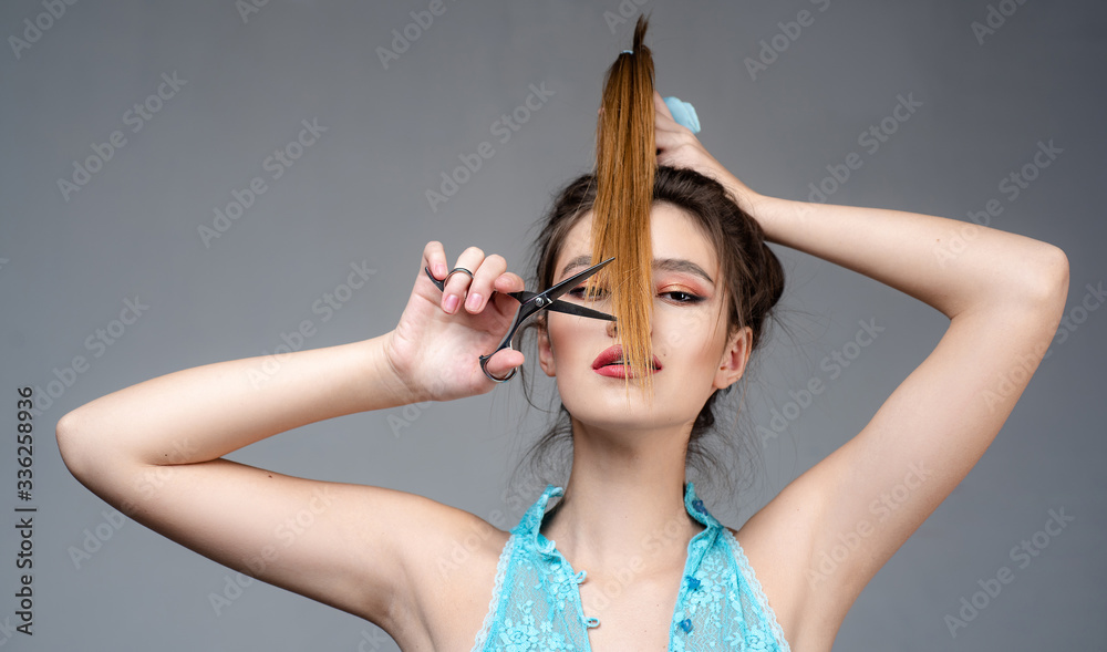 Portrait of attractive woman holding hair. Blonde girl cut forelock ...