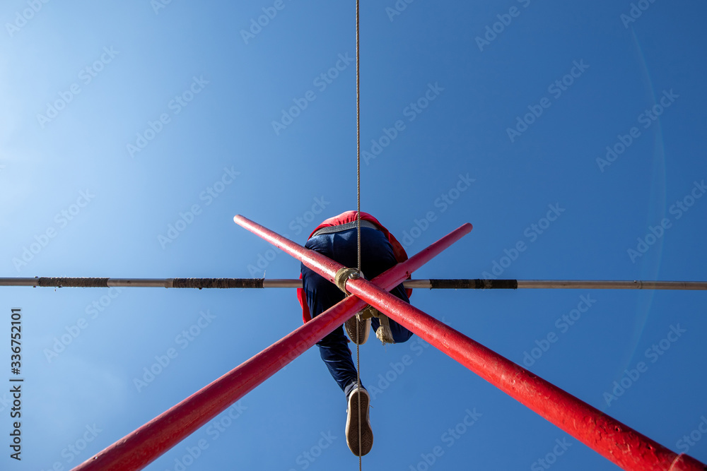 bottom view of a man tightrope walker with a pole. circus performance ...
