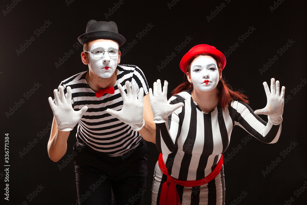 Portrait of man and woman mime artists performing, isolated on black ...