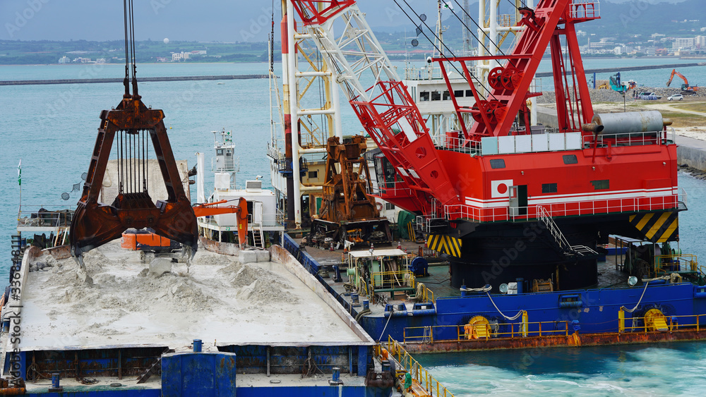 Huge excavator on floating platform in the blue water of the Pacific ...