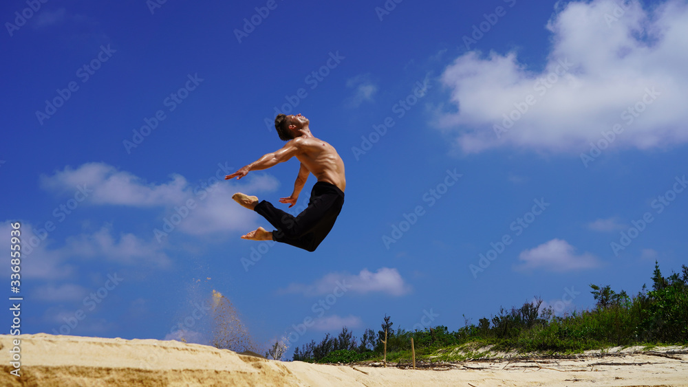 young sporty european guy jumping acrobatics twine. muscular man on the ...